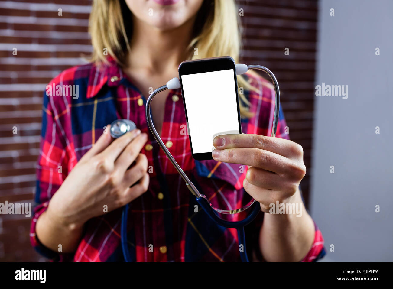 Pretty blonde woman showing smartphone screen Stock Photo - Alamy
