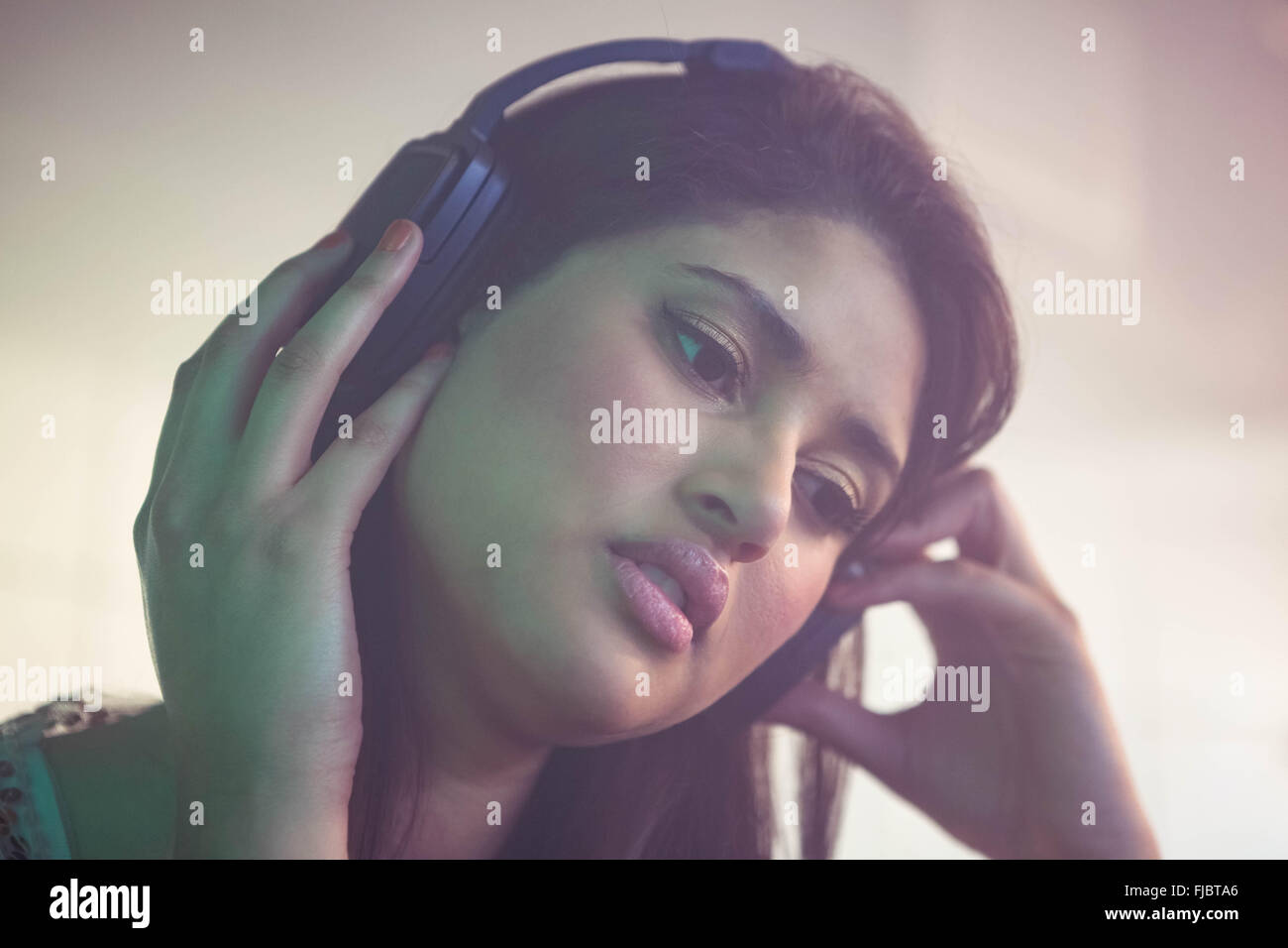 Pretty female DJ listening music on headphone Stock Photo - Alamy