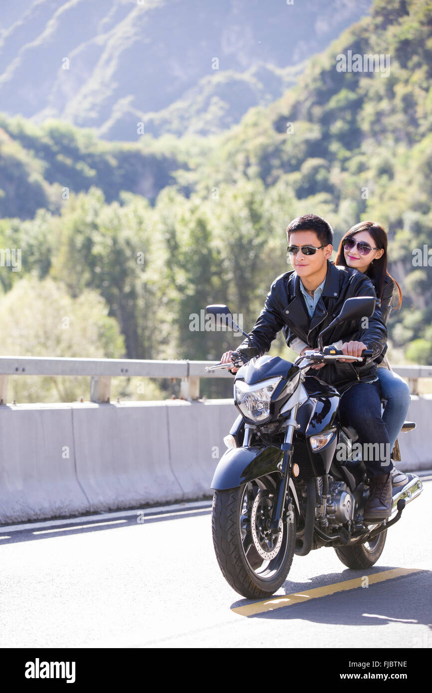 Young Chinese couple riding motorcycle together Stock Photo - Alamy