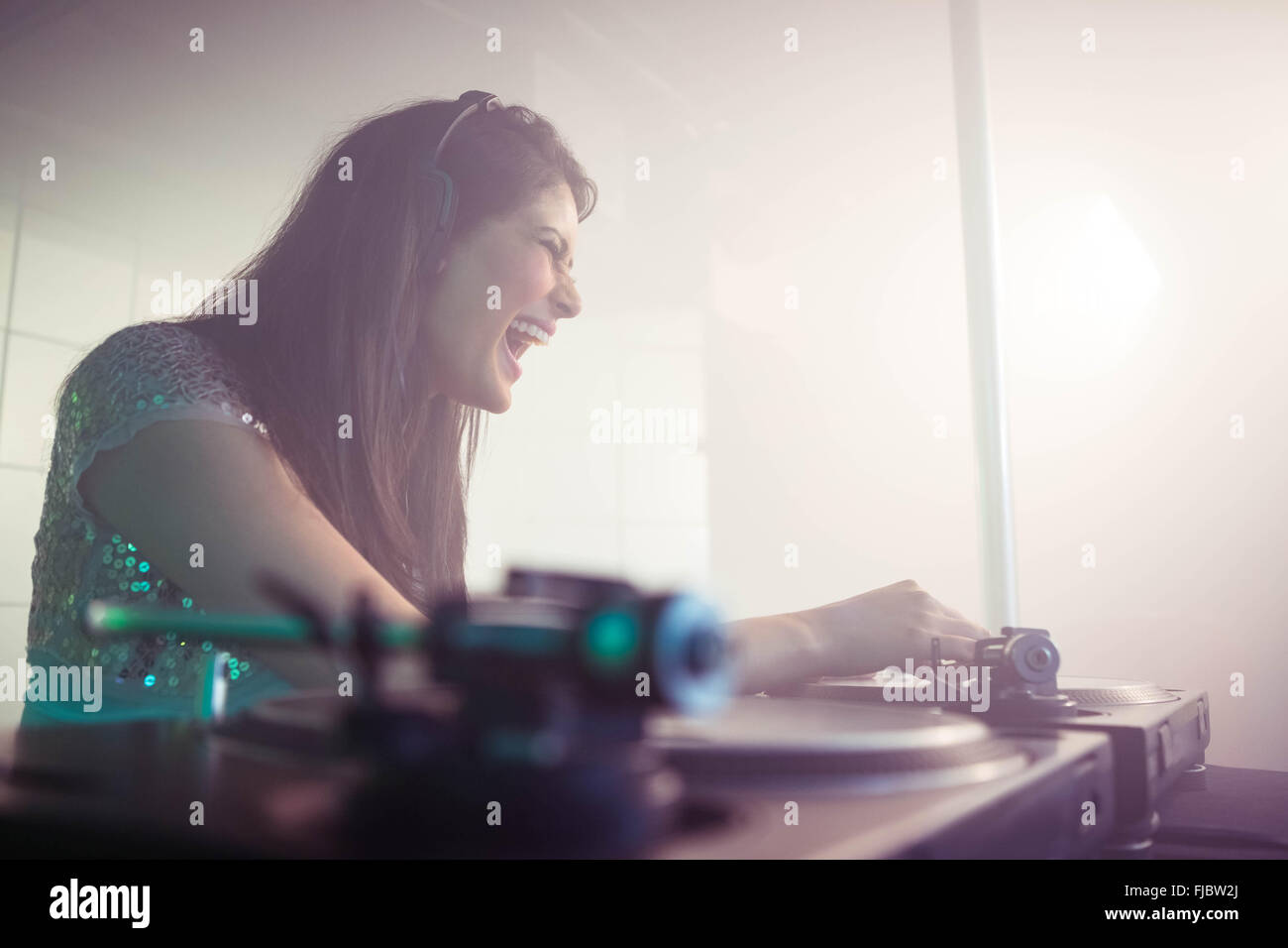Pretty female DJ playing music Stock Photo - Alamy