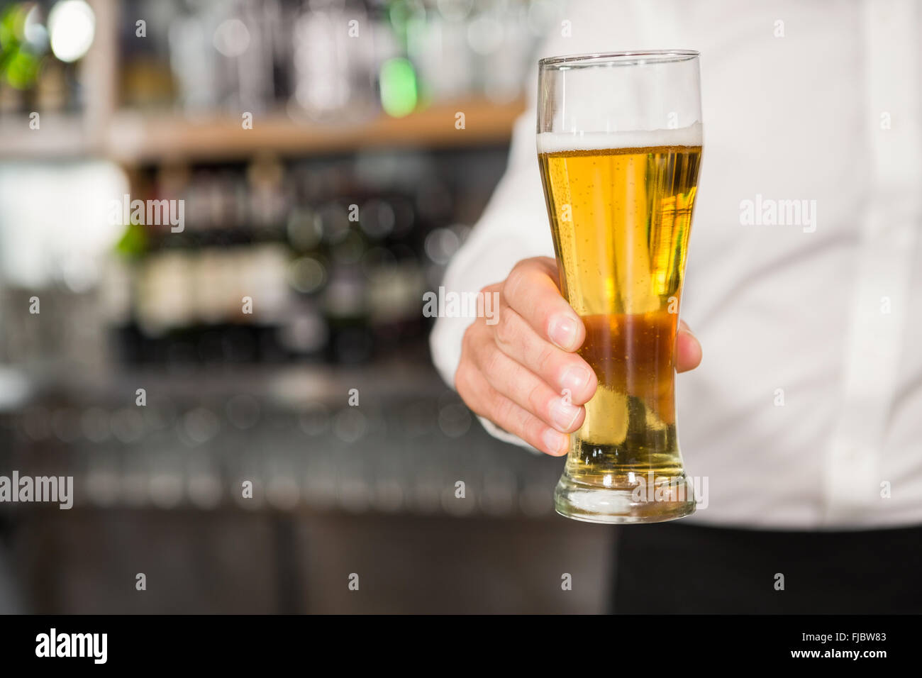 Handsome bar tender giving a pint for a customer Stock Photo - Alamy