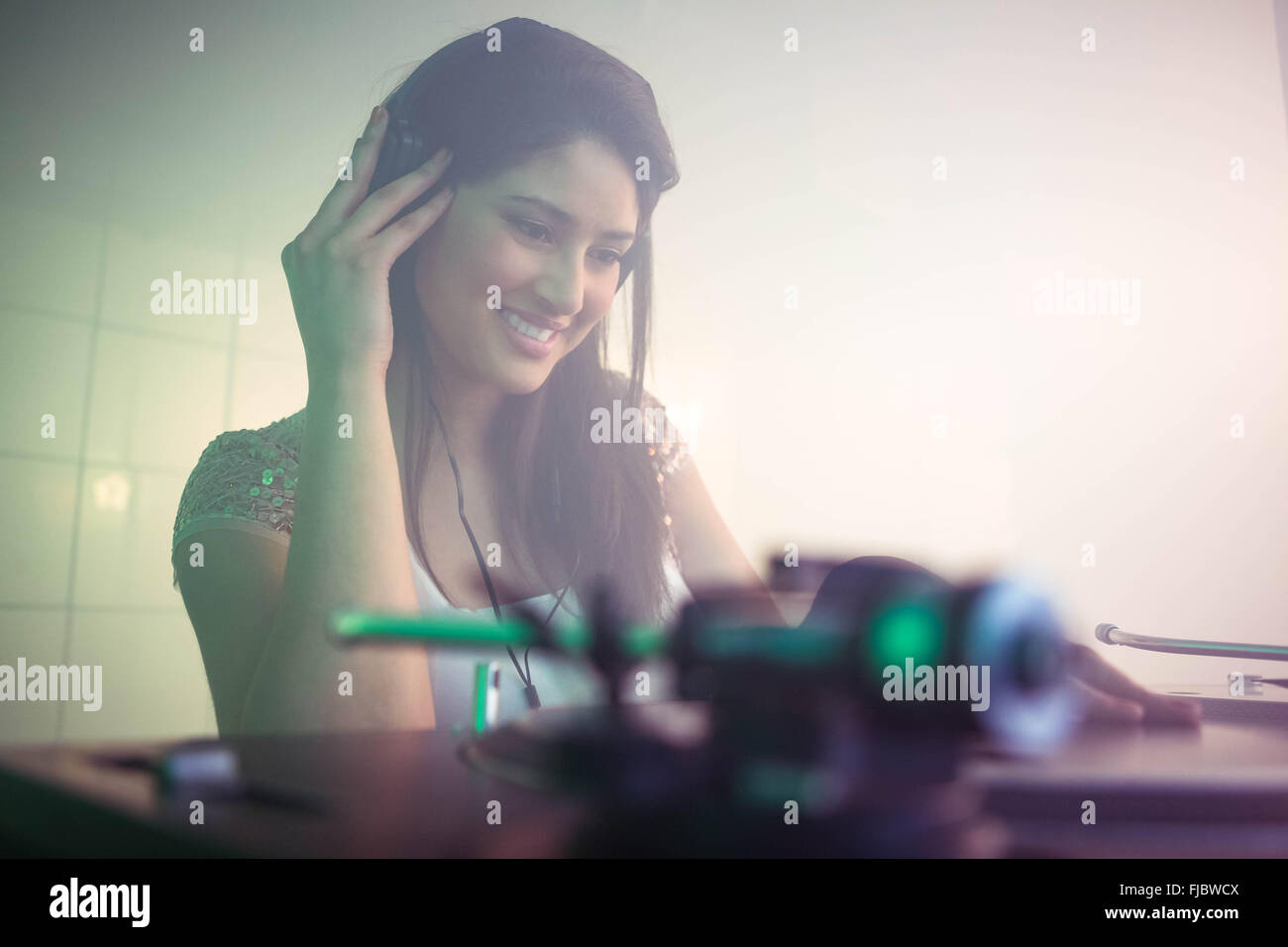 Pretty female DJ playing music Stock Photo - Alamy