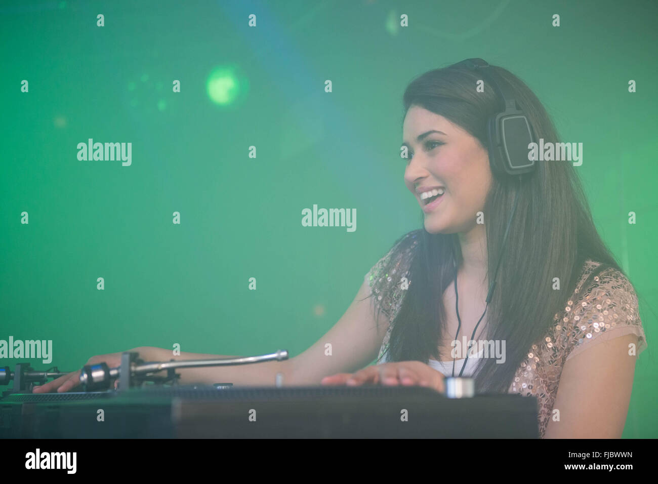 Pretty female DJ playing music Stock Photo - Alamy