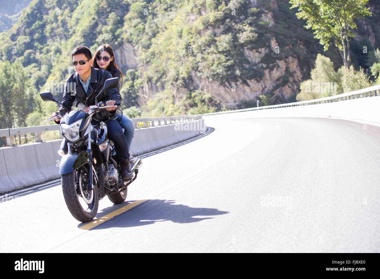 Young Chinese couple riding motorcycle together Stock Photo - Alamy