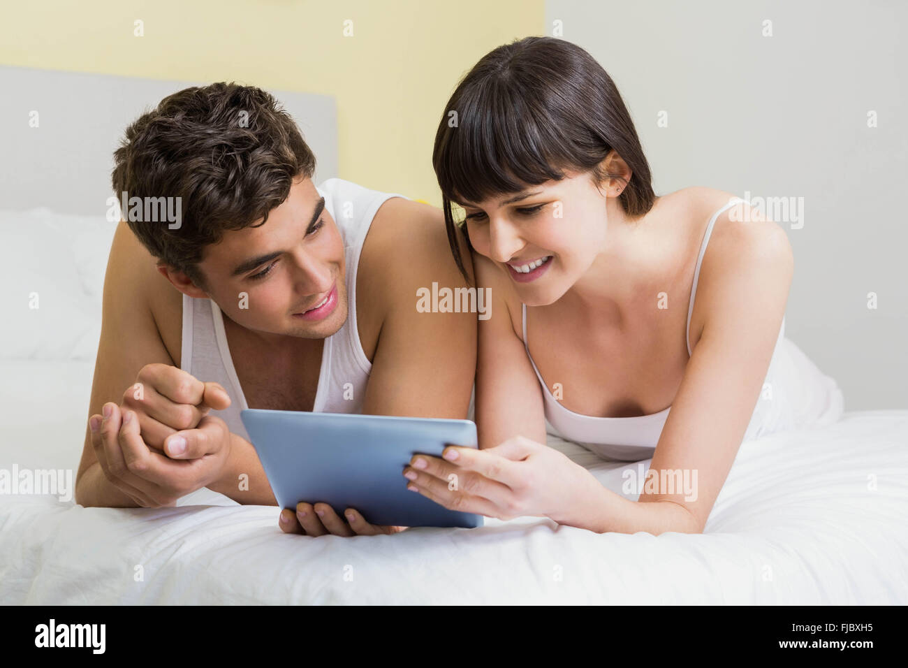 Couple using digital tablet on bed Stock Photo - Alamy