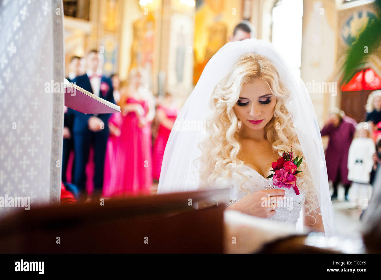 Style blonde bride kneeling at church Stock Photo - Alamy