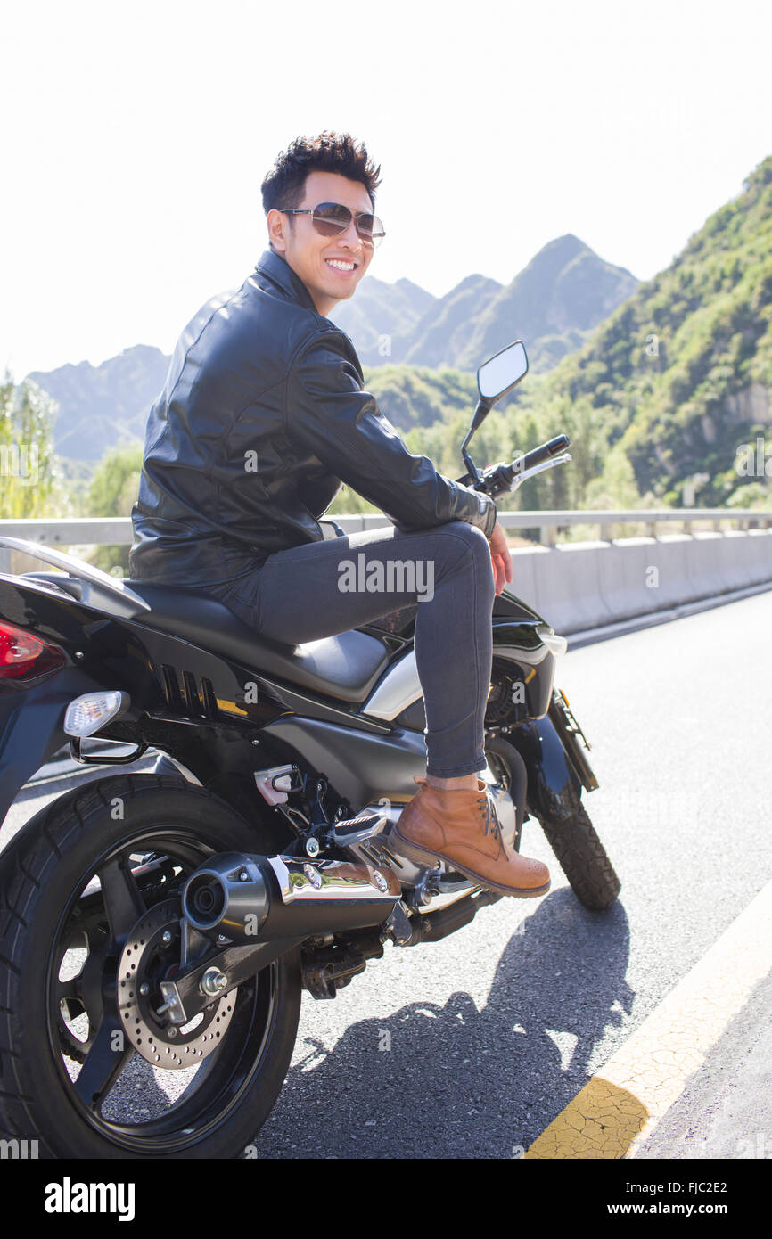 Young Chinese man riding motorcycle Stock Photo - Alamy