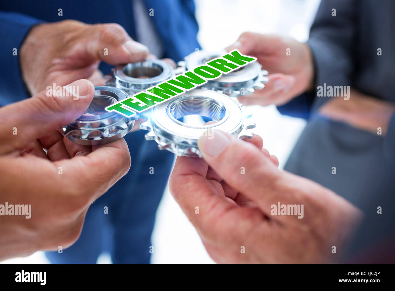 Teamwork against business colleagues holding cog Stock Photo - Alamy