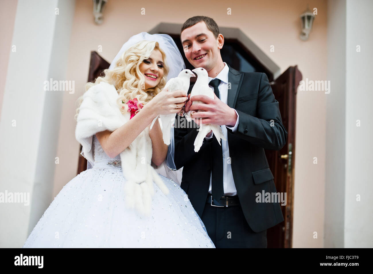 Wedding couple with two white pigeons Stock Photo - Alamy