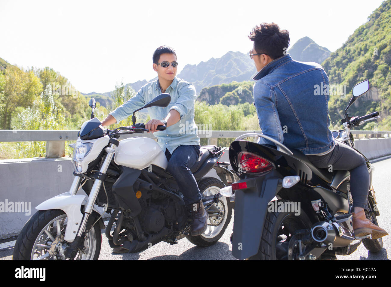 Young Chinese men riding motorcycle Stock Photo - Alamy