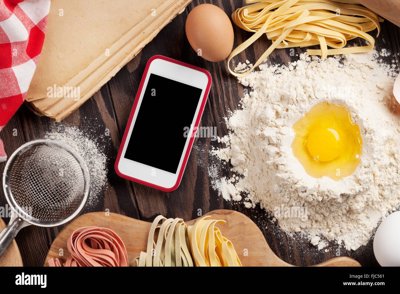Homemade pasta cooking and smartphone with blank screen for your app ...