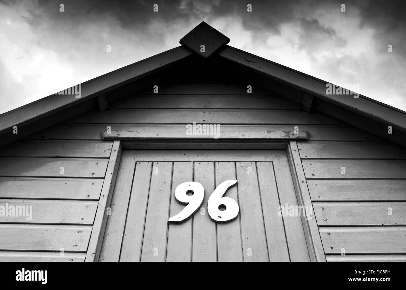 Black and white close-up of angled roofline, number 96 on door, wooden ...
