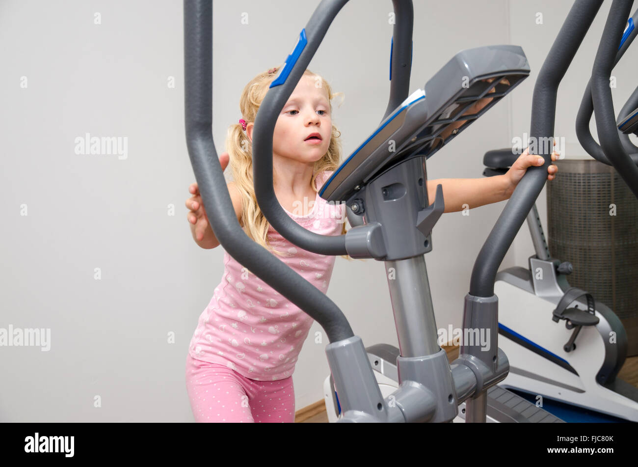 little blond girl training in equipment in the gym Stock Photo - Alamy