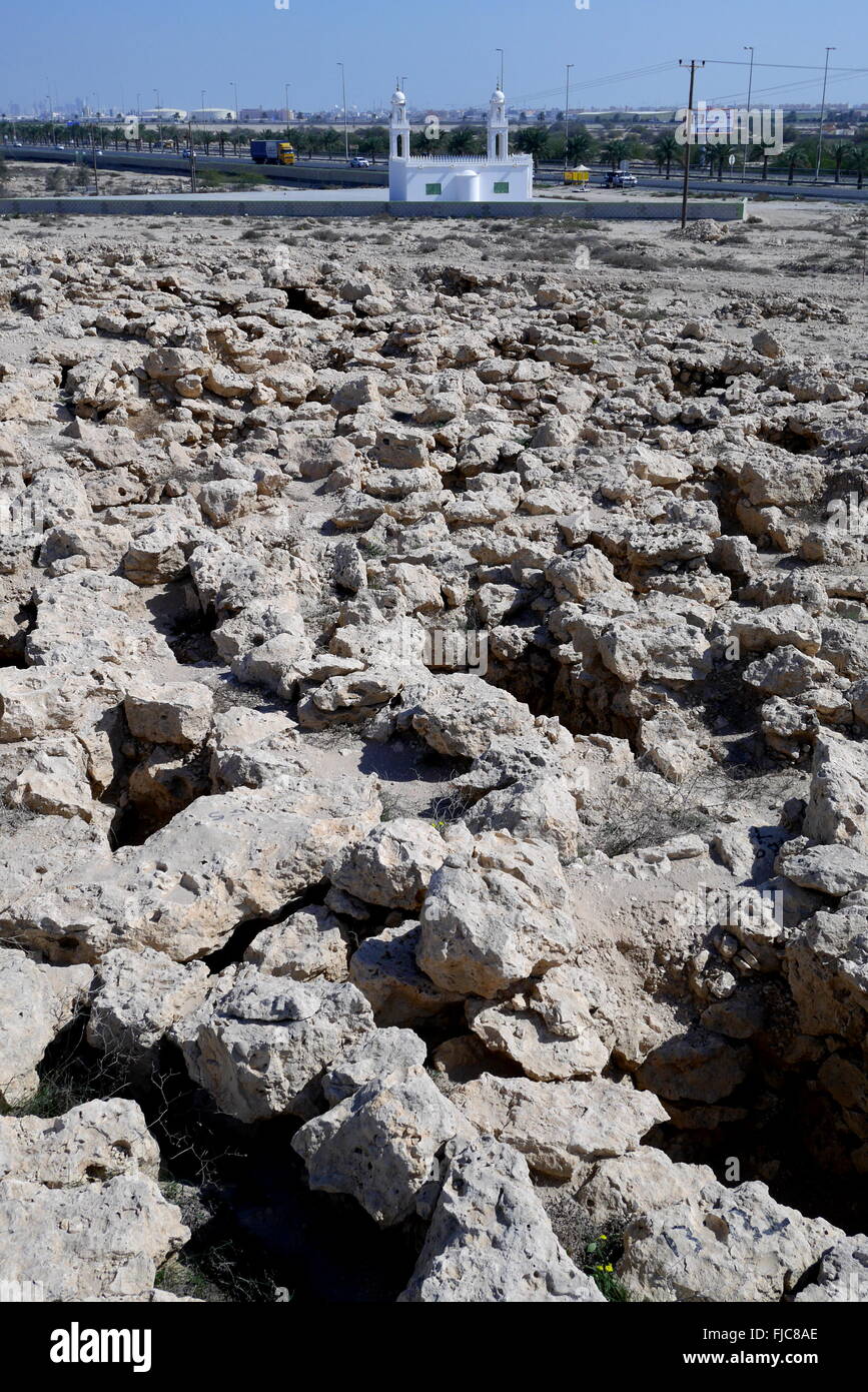 Open graves at the Dilmun era Saar Settlement, with a modern mosque in ...