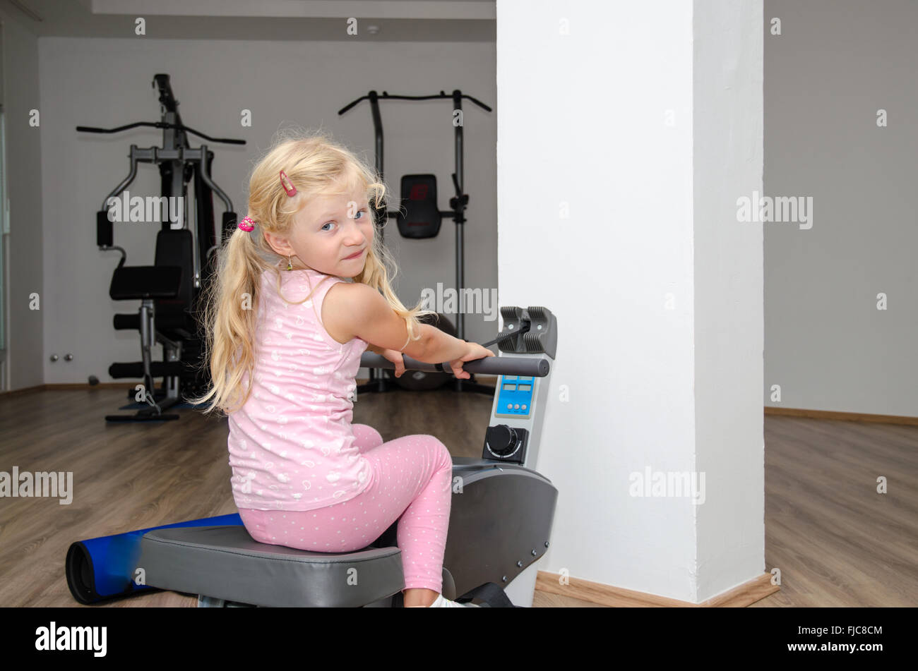 little blond girl doing exercise in the gym with equipment Stock Photo ...