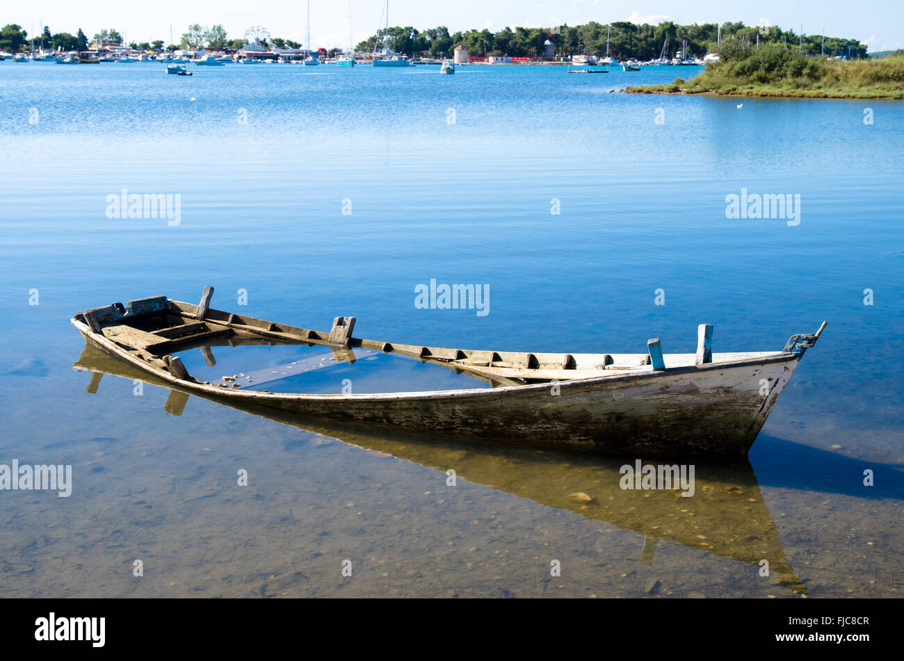 little wooden scuttled boat in the sea Stock Photo - Alamy