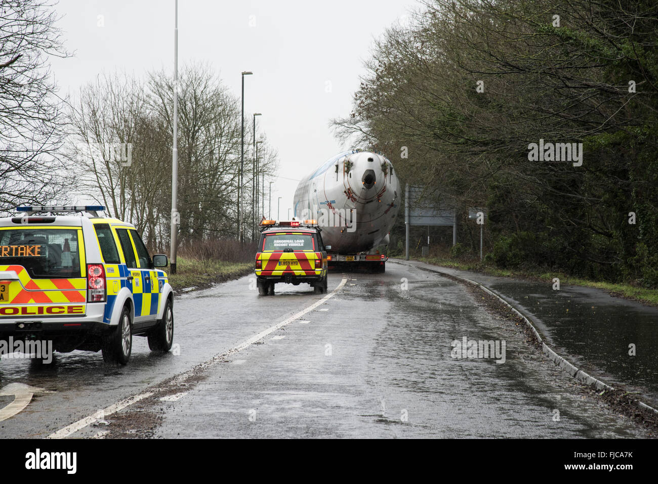 Police patrol vehicle escorts an abnormal load consisting of an old ...