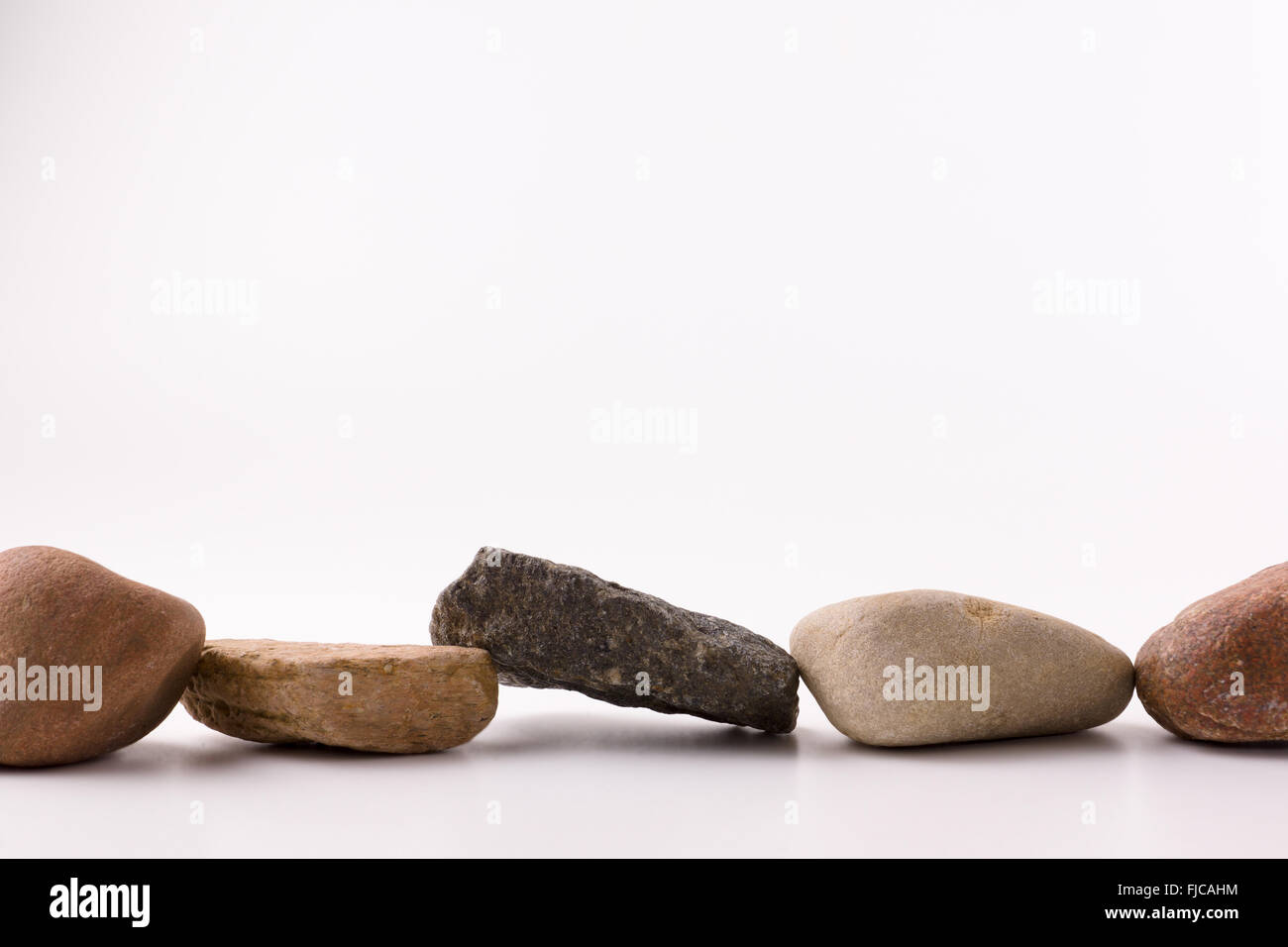 long line of stones on a white background Stock Photo - Alamy