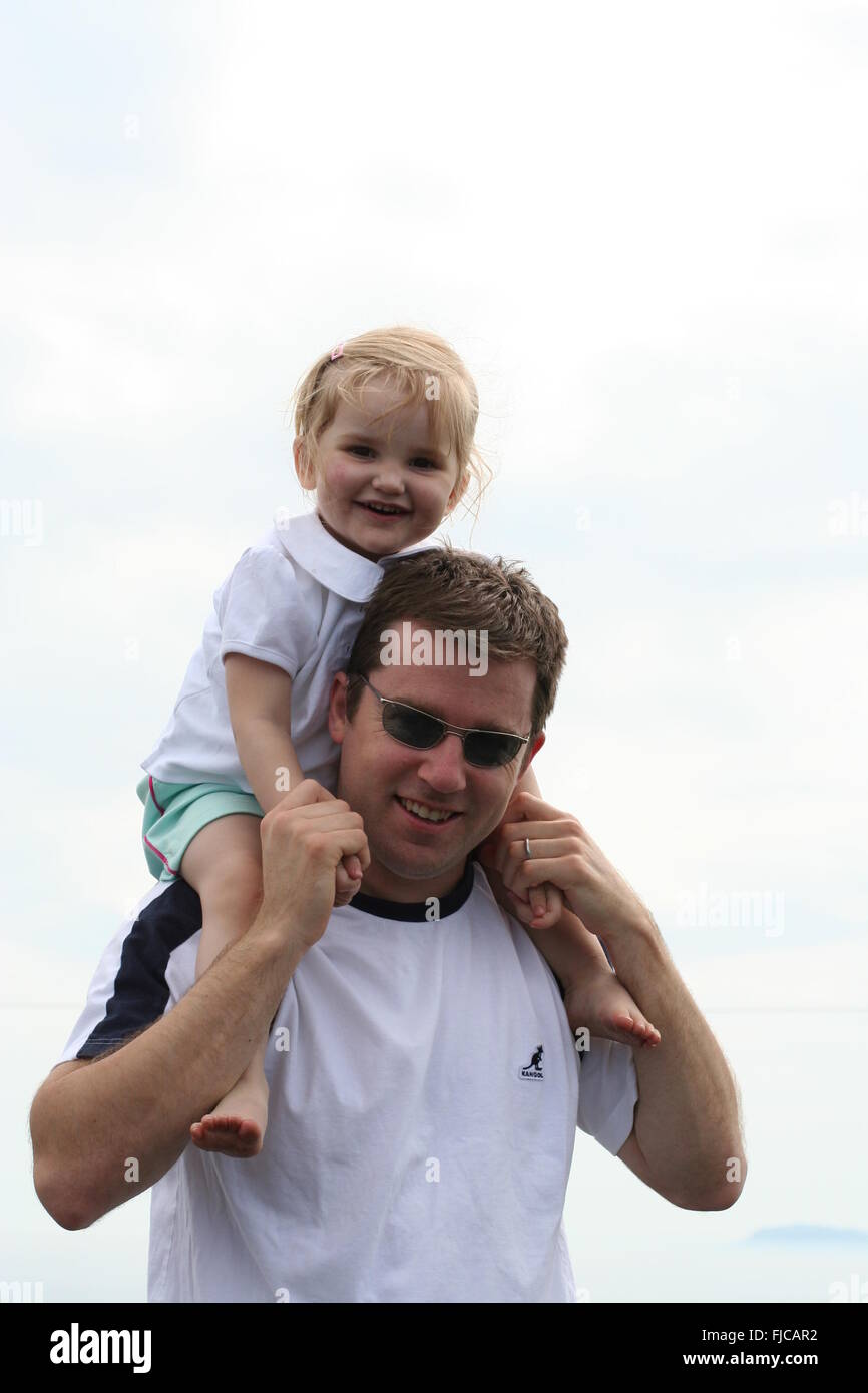 Little girl child kid sitting on dad father daddy's shoulders father ...