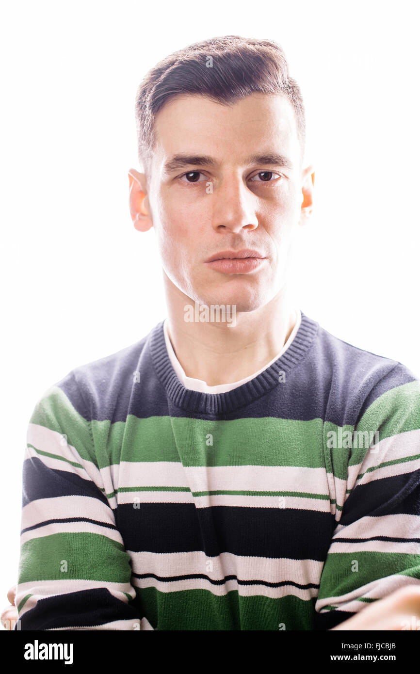 Portrait of a smart serious young man standing against white background ...