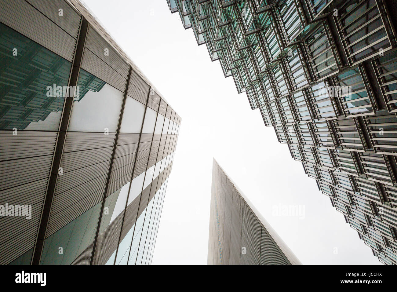 A coloured photo looking up capturing three different buildings on a ...