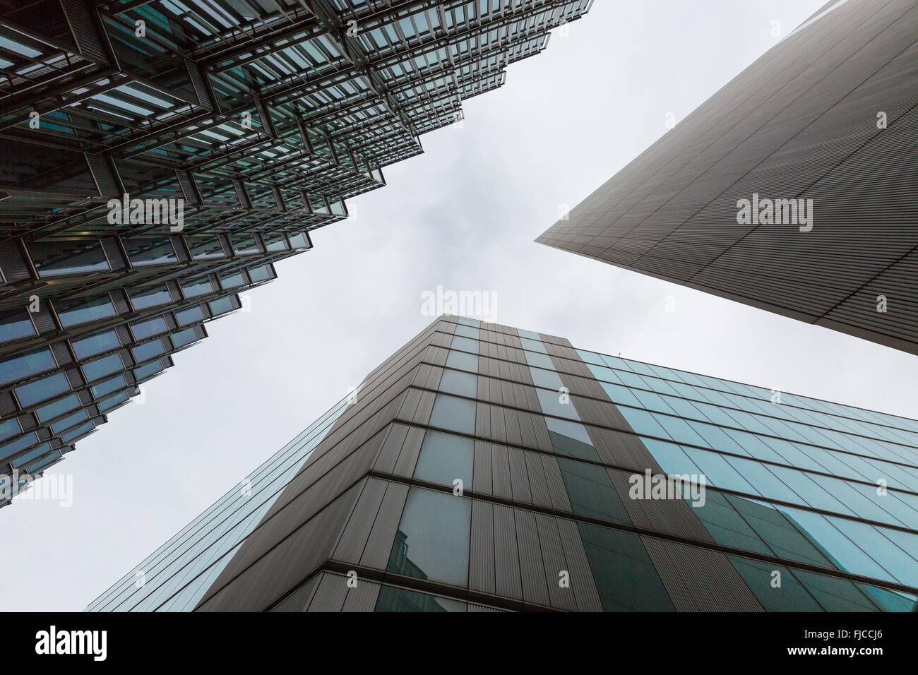A coloured photo looking up capturing three different buildings on a ...