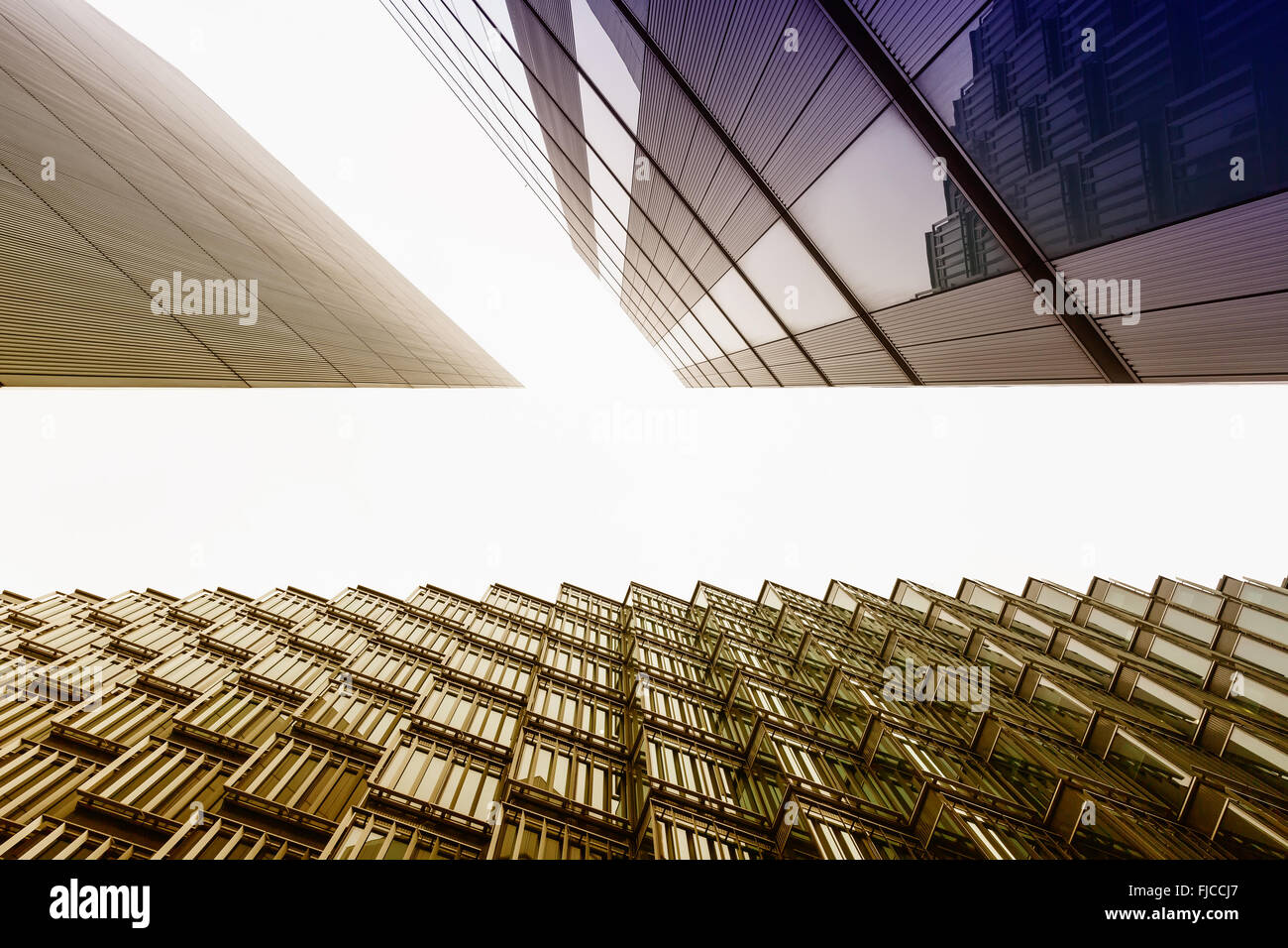 A coloured photo looking up capturing three different buildings on a ...