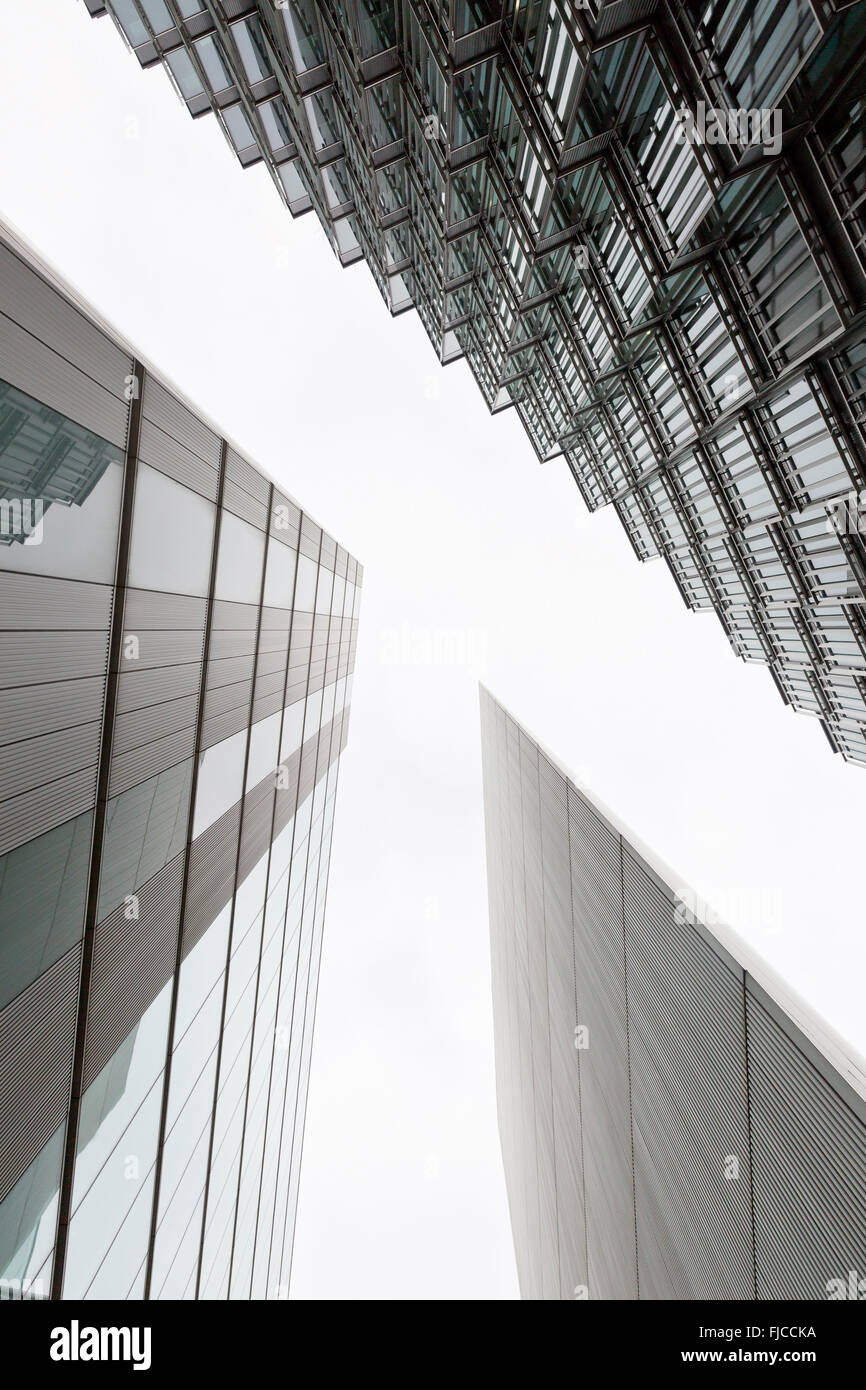 A photo looking up capturing three different buildings on an angle on a ...