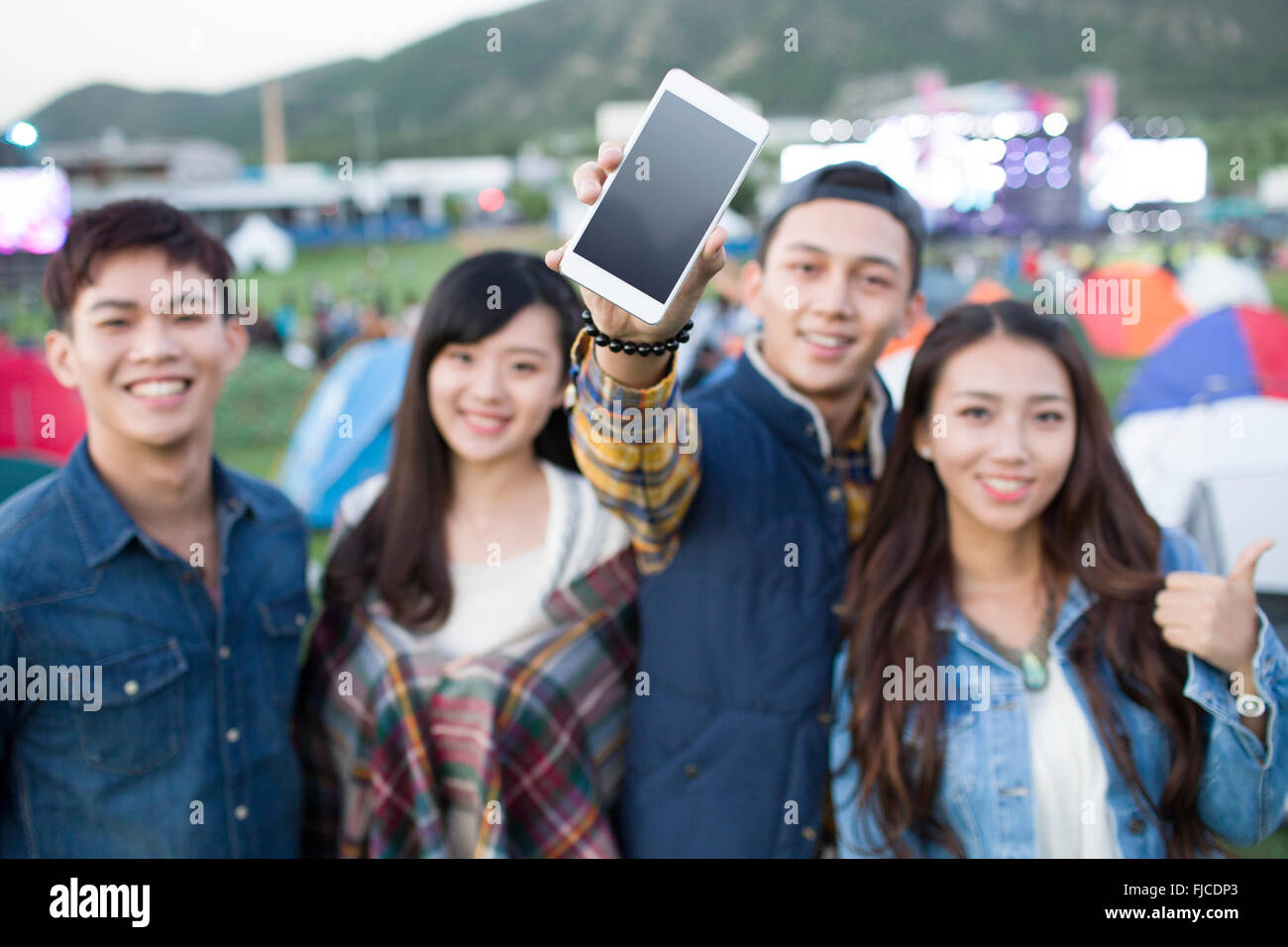 Happy Chinese friends showing a smart phone Stock Photo - Alamy