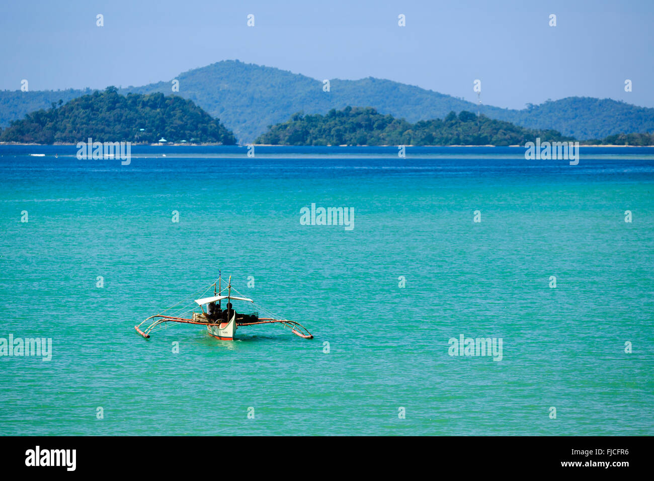 Outrigger canoe approaching land in beautiful Bay in Philippines Stock ...