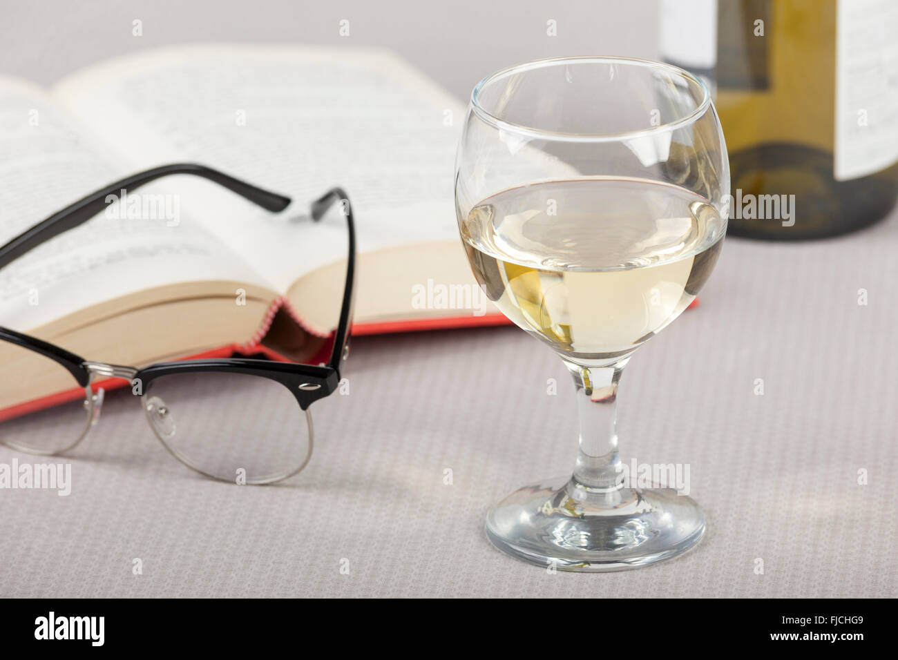 Glass of wine on a table with an open book and reading glasses Stock ...