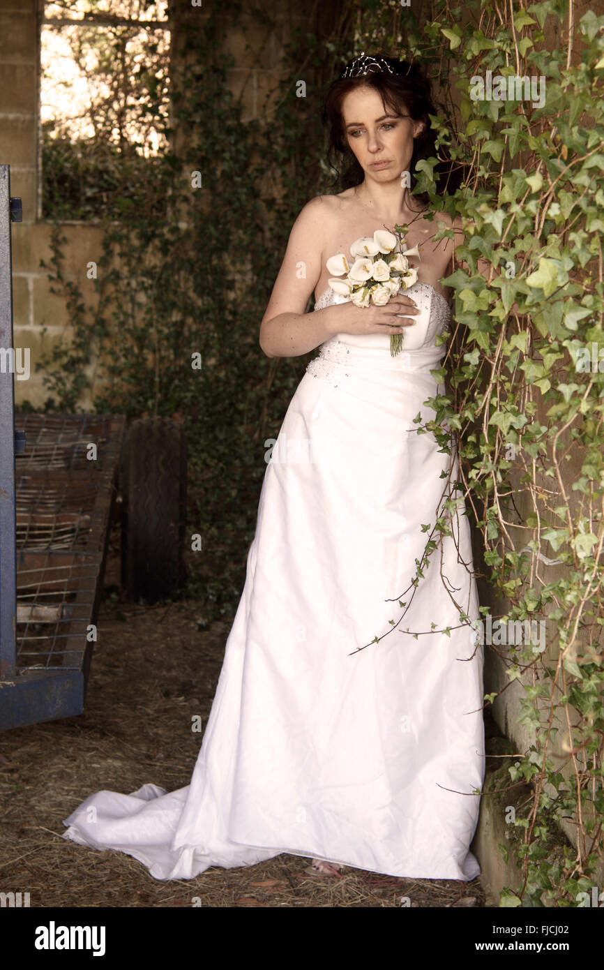 Sad mature bride posing in an old barn Stock Photo - Alamy