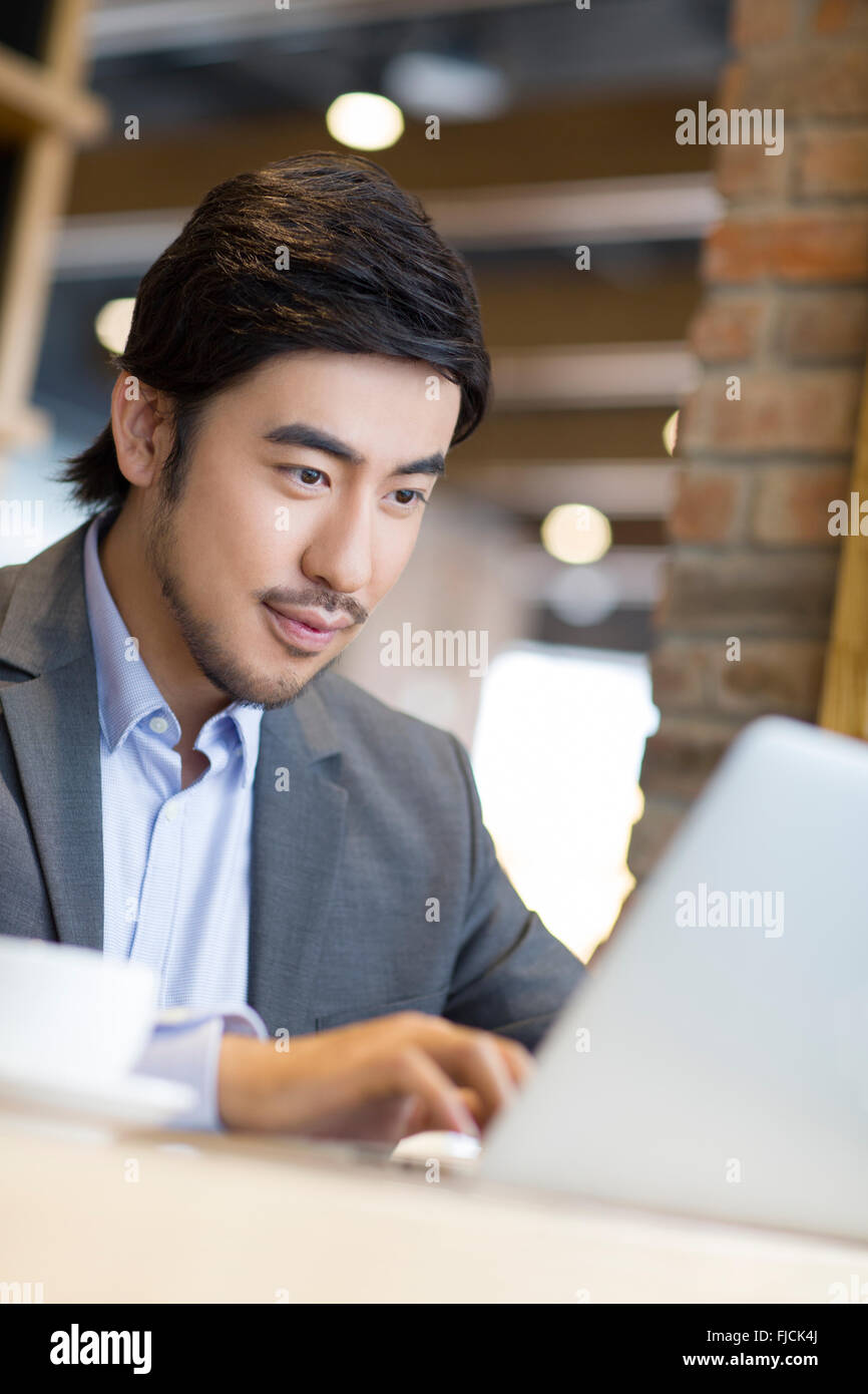 Chinese businessman working with laptop Stock Photo - Alamy