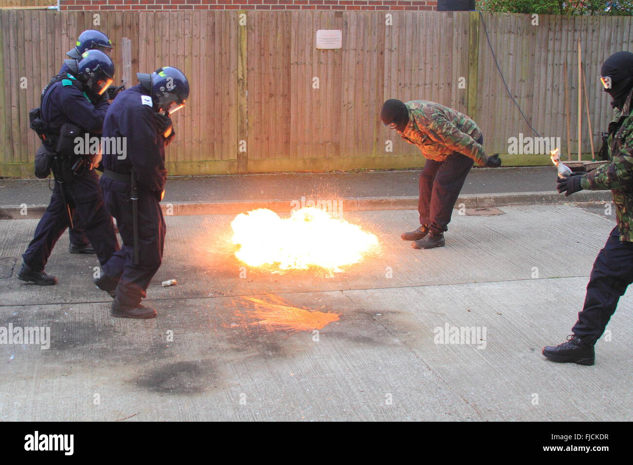 A public order unit move through flames after petrol bombs are thrown ...