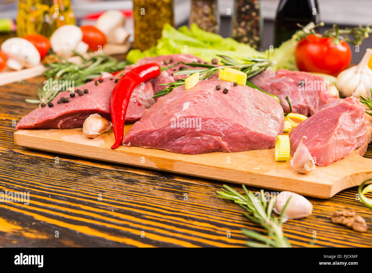 Cutting board full of red raw meat ready to be tenderized and cooked ...