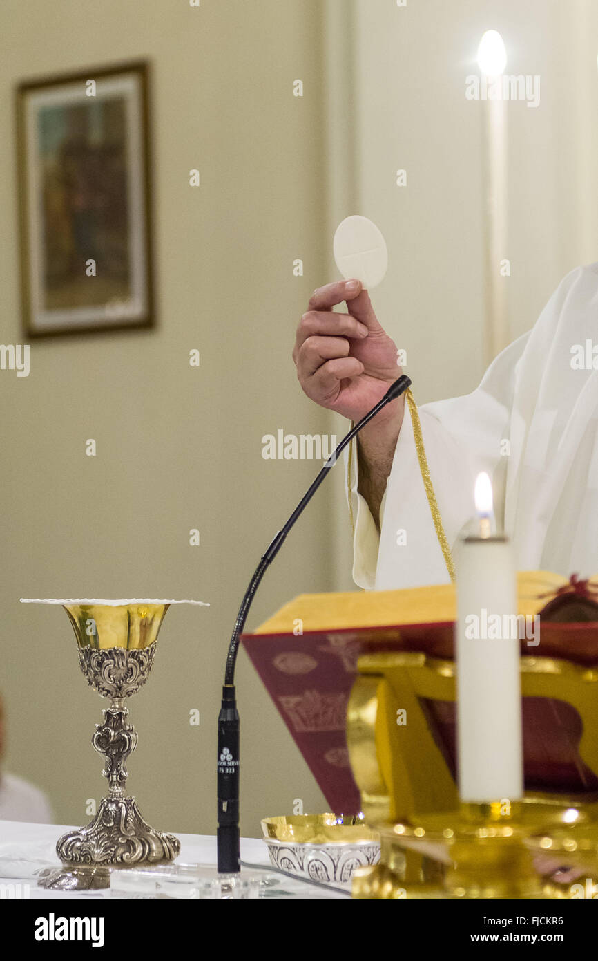 Priest celebrating the communion with goblet and holy bread Stock Photo ...