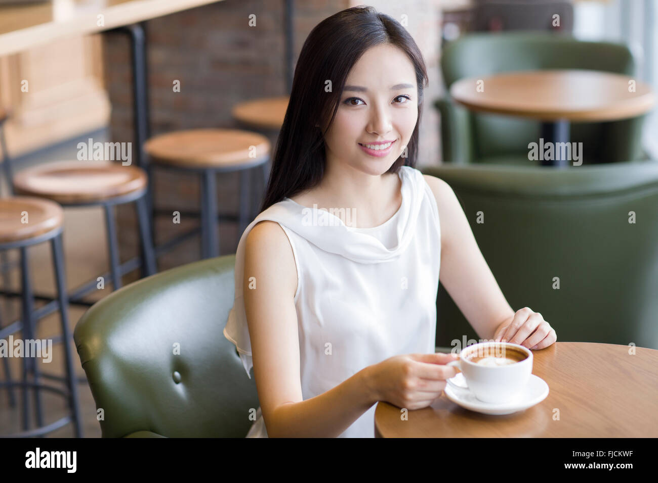 Young Chinese woman drinking coffee in café Stock Photo - Alamy
