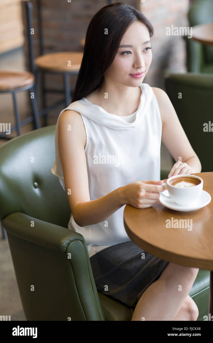 Young Chinese woman drinking coffee in café Stock Photo - Alamy