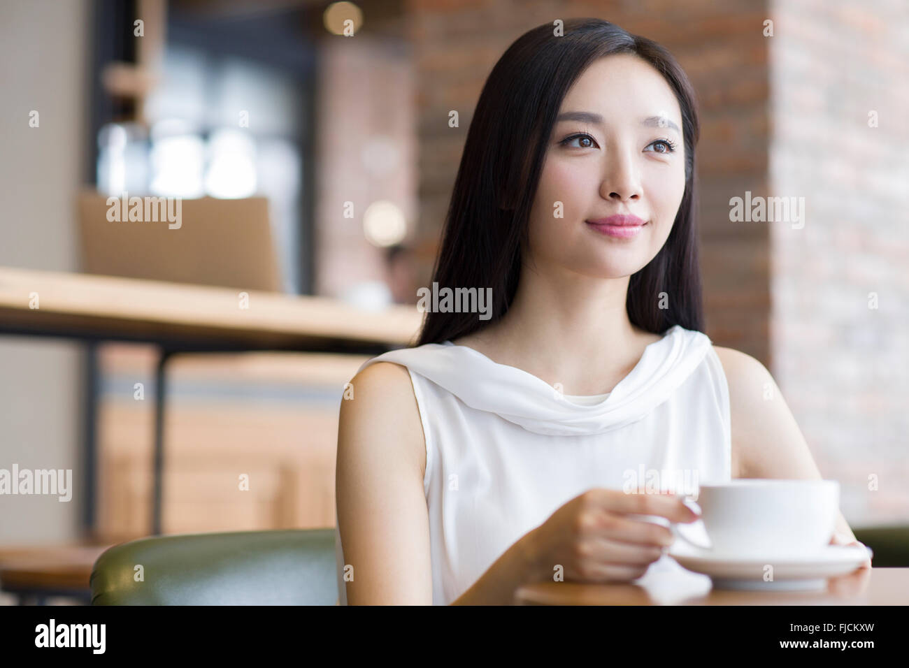 Young Chinese woman drinking coffee in café Stock Photo - Alamy