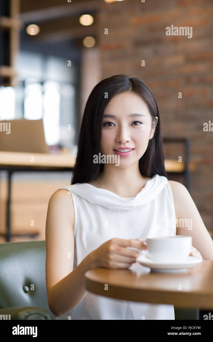 Young Chinese woman drinking coffee in café Stock Photo - Alamy