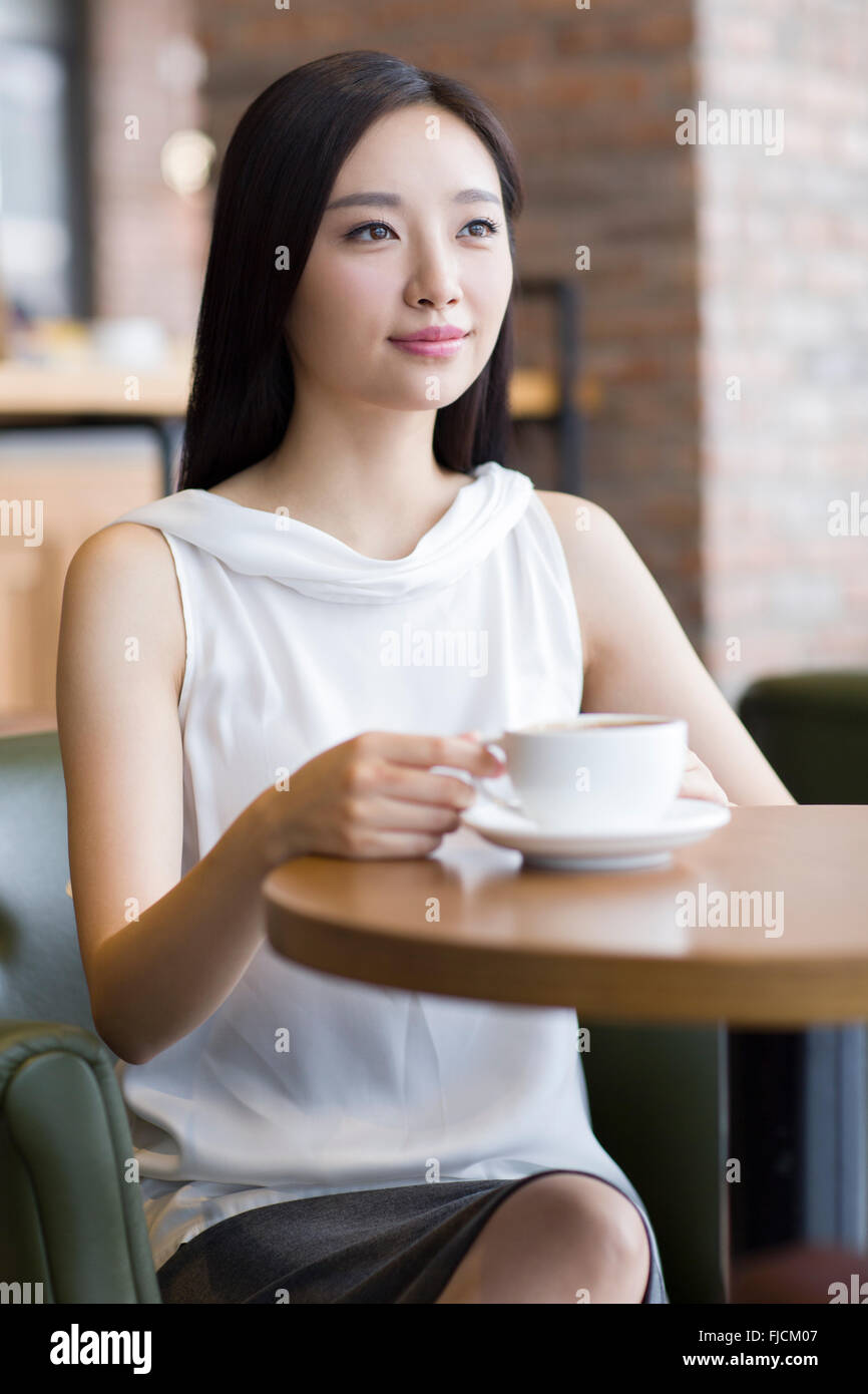 Young Chinese woman drinking coffee in café Stock Photo - Alamy