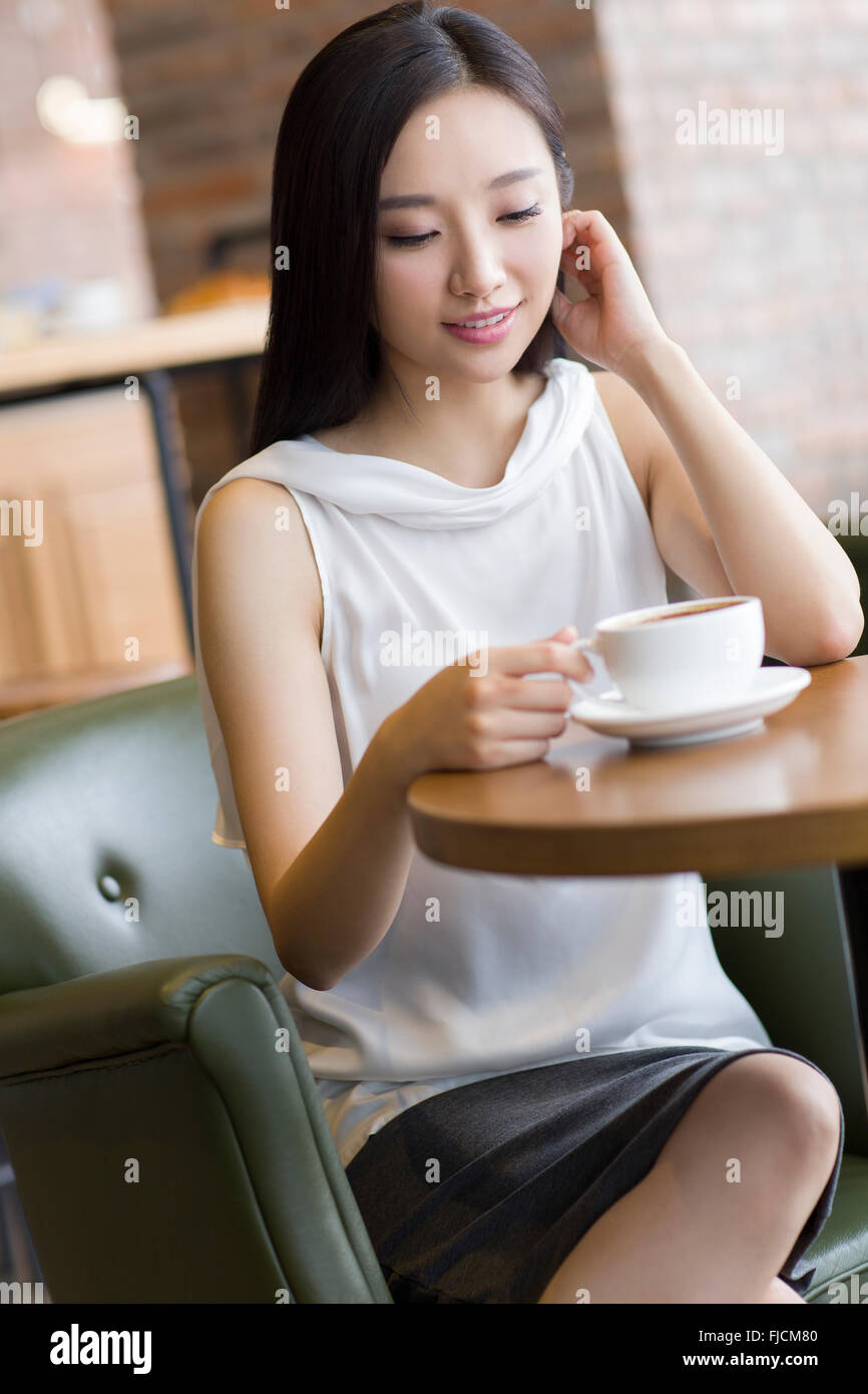 Young Chinese woman drinking coffee in café Stock Photo - Alamy