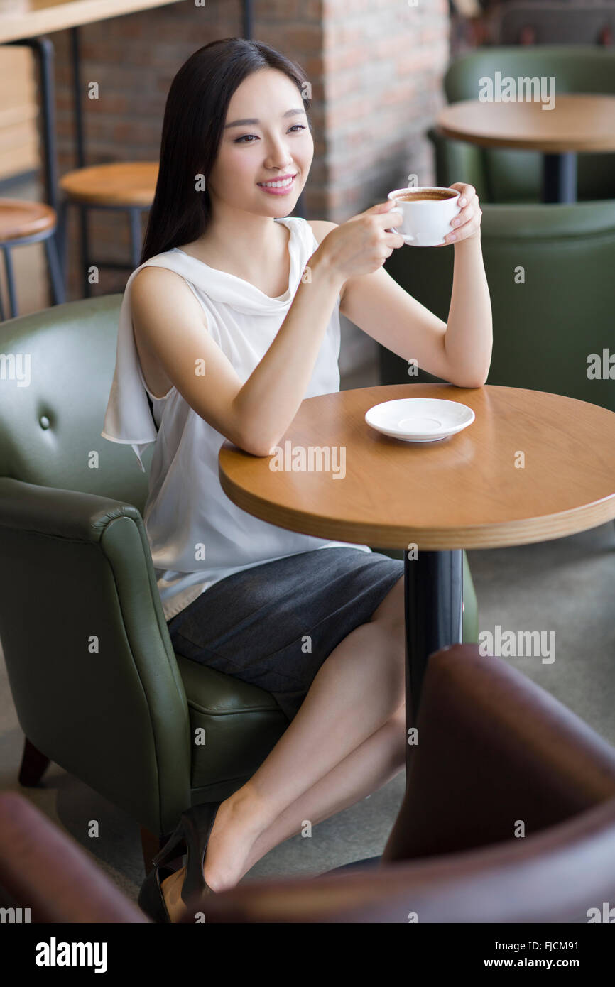 Young Chinese woman drinking coffee in café Stock Photo - Alamy