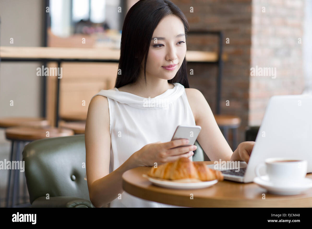Young Chinese woman working with laptop in café Stock Photo - Alamy