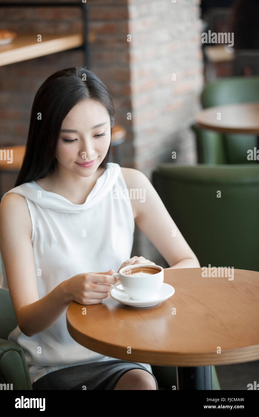 Young Chinese woman drinking coffee in café Stock Photo - Alamy