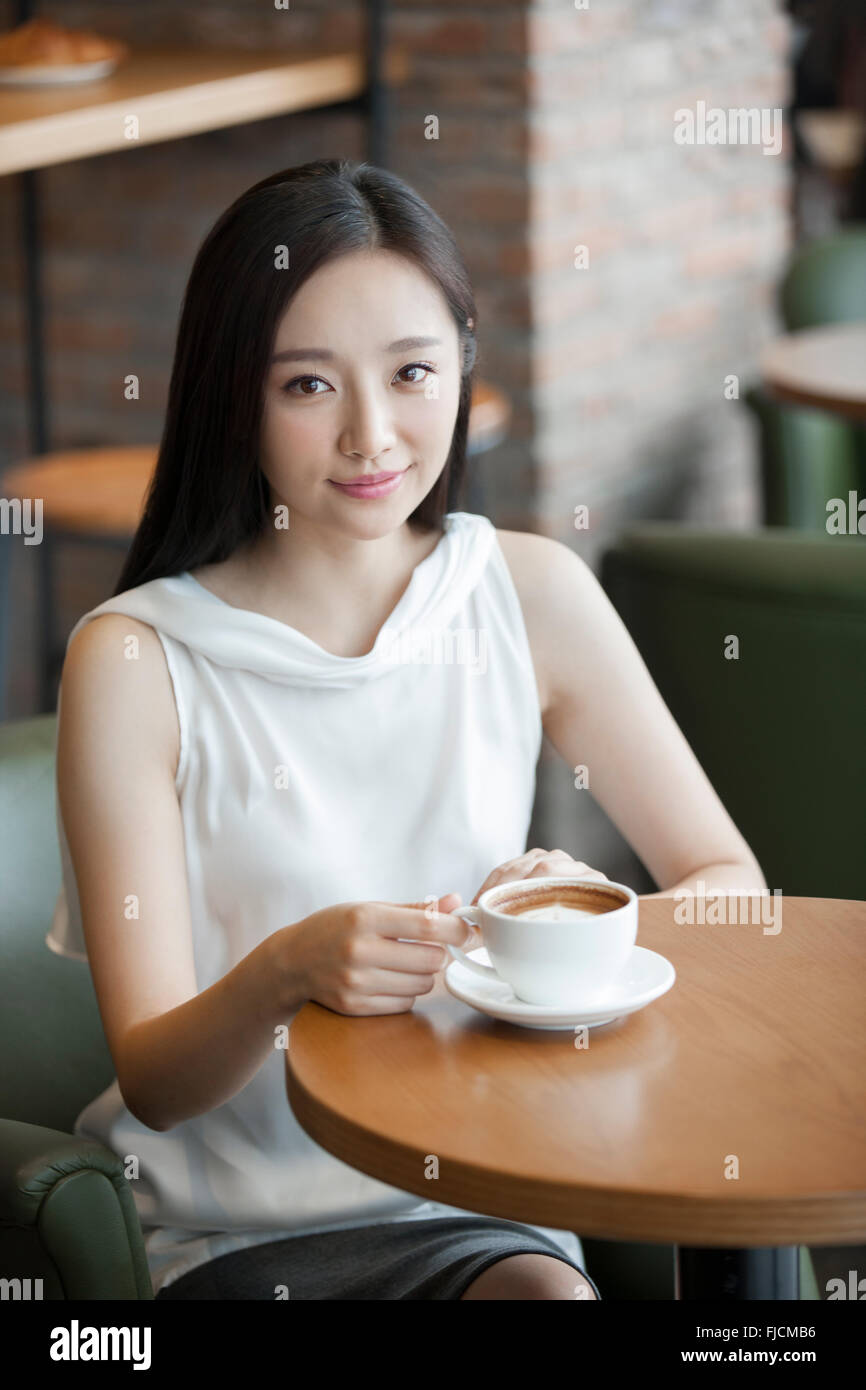Young Chinese woman drinking coffee in café Stock Photo - Alamy