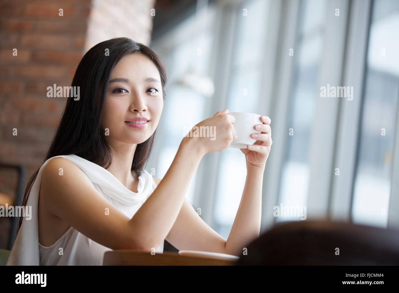 Young Chinese woman drinking coffee in café Stock Photo - Alamy