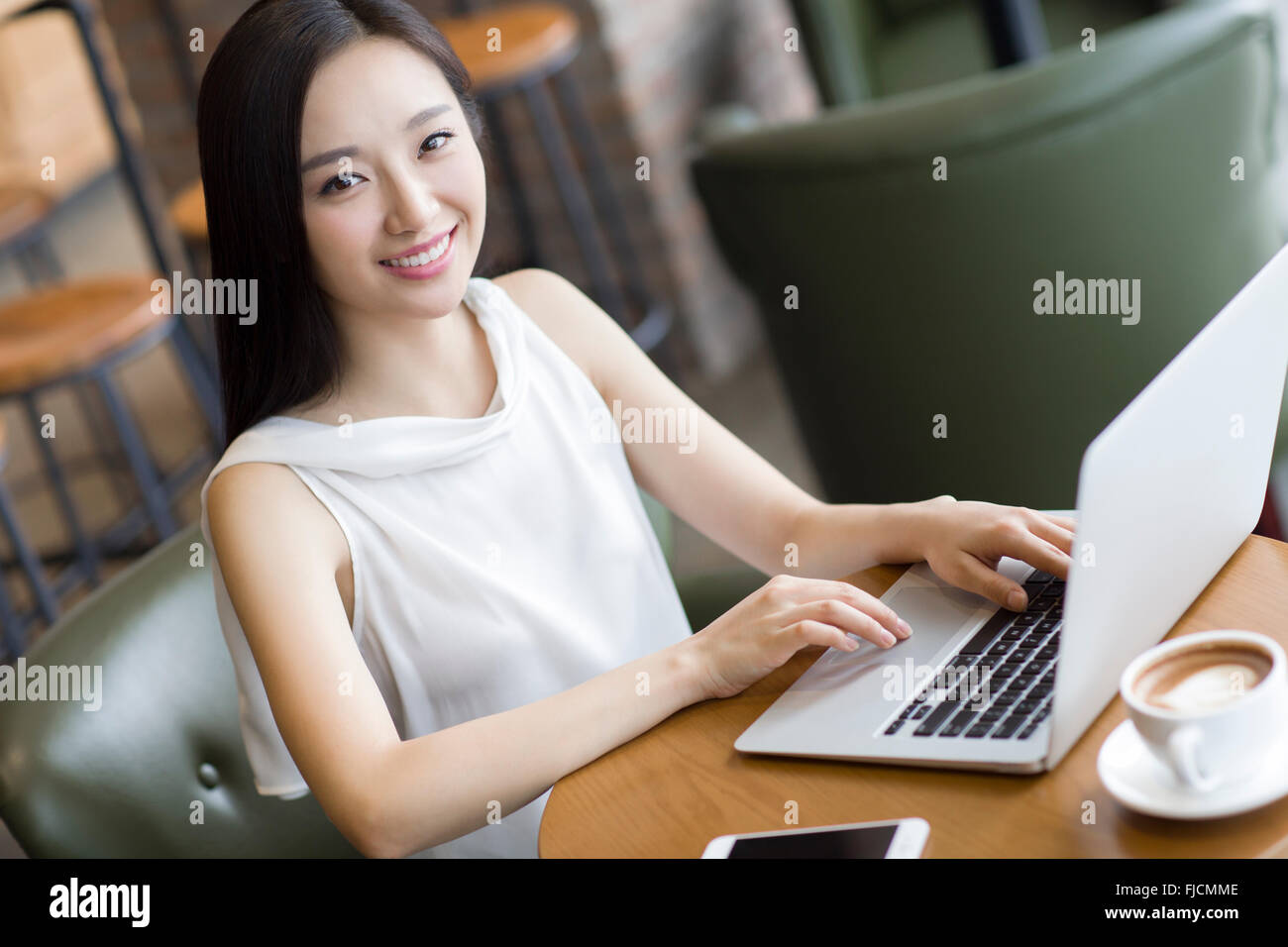 Young Chinese woman working with laptop in café Stock Photo - Alamy