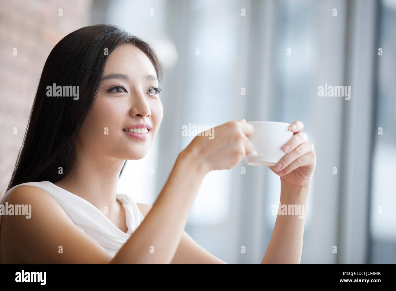 Young Chinese woman drinking coffee in café Stock Photo - Alamy