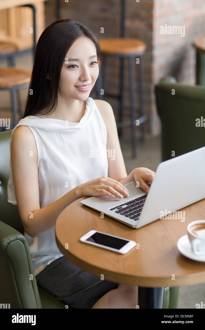 Young Chinese woman working with laptop in café Stock Photo - Alamy
